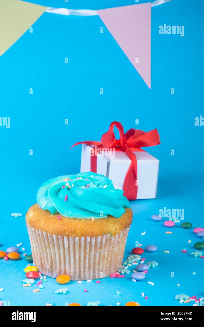 composition of cupcake with present gift box with red ribbon on blue ...