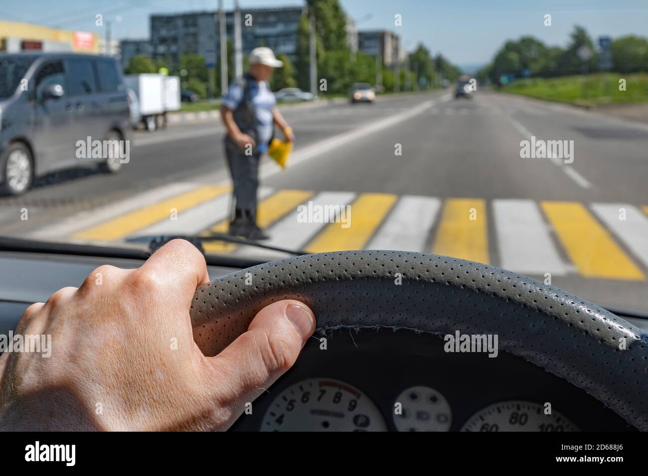 driver hand on the steering wheel of a car against the background of a ...
