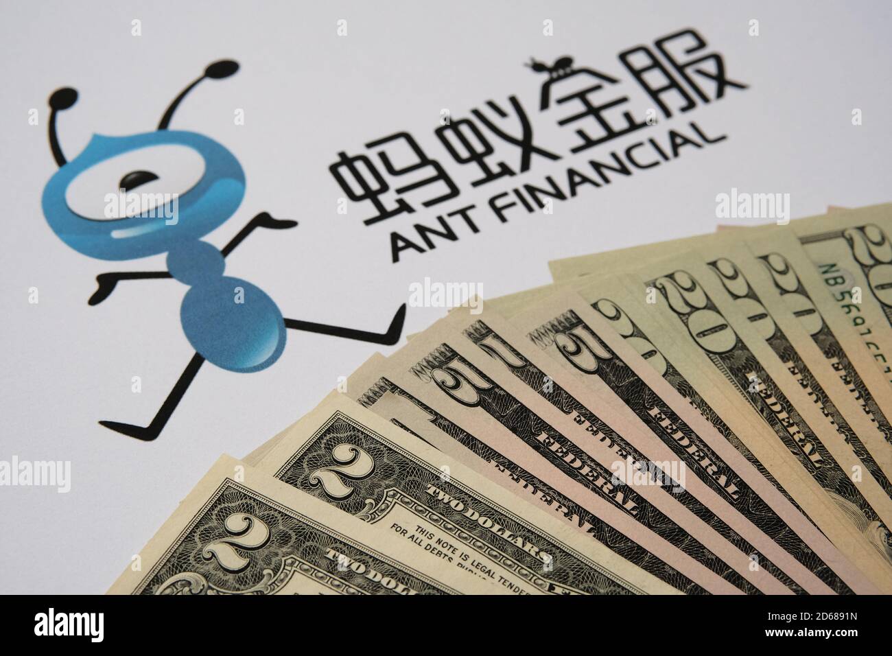 Pile of dollar notes spread on a document with blurred Ant Financial ...