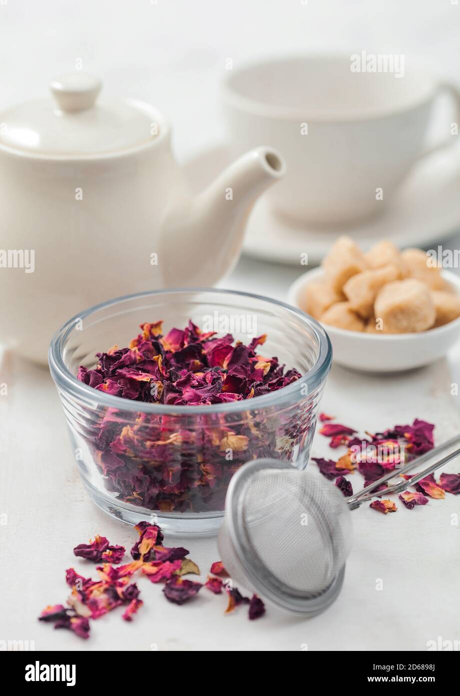 Fresh organic rose petals with strainer infuser and white ceramic ...