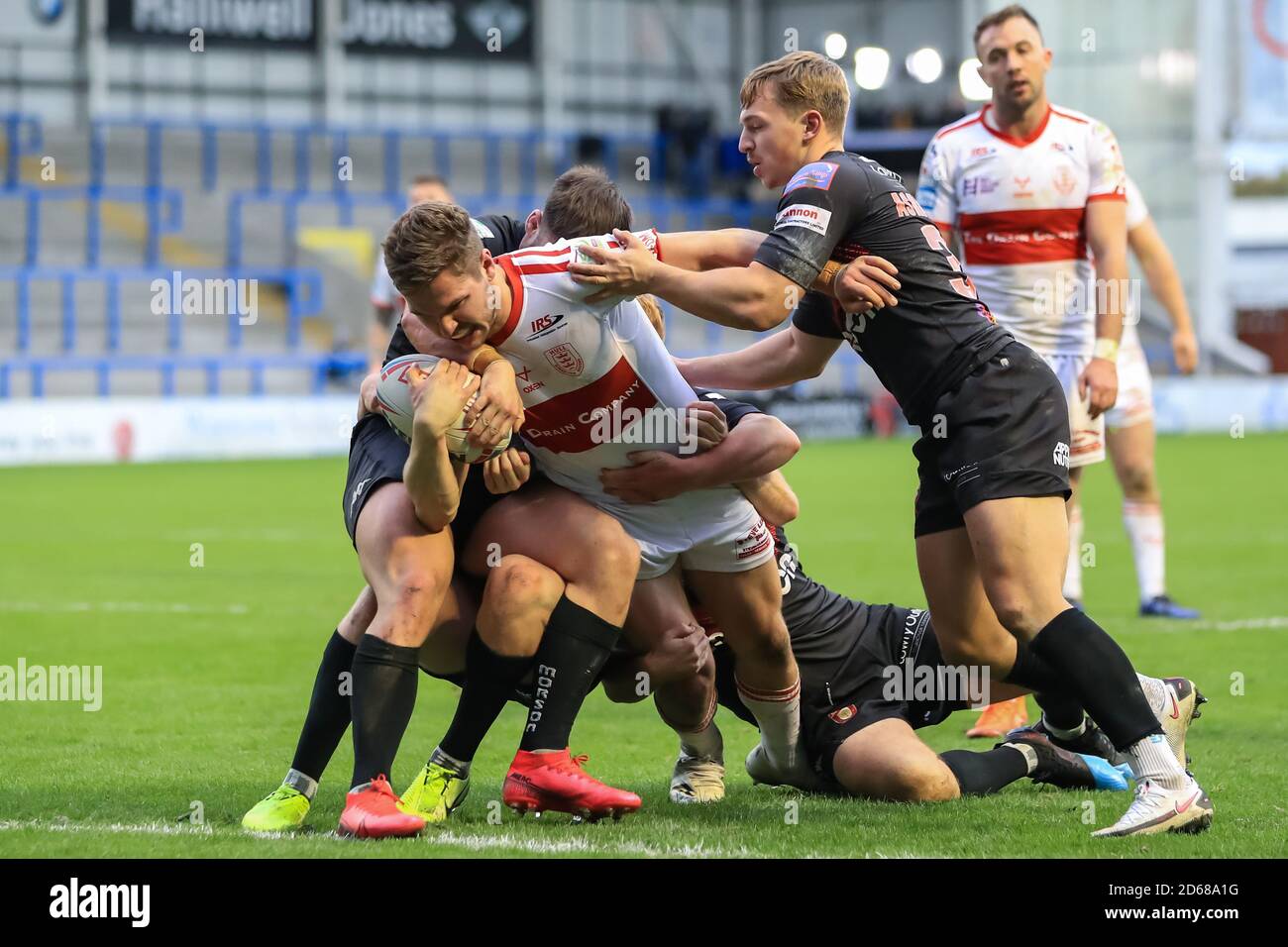 Matt Parcell (9) of Hull KR is held back from scoring by the Salford ...