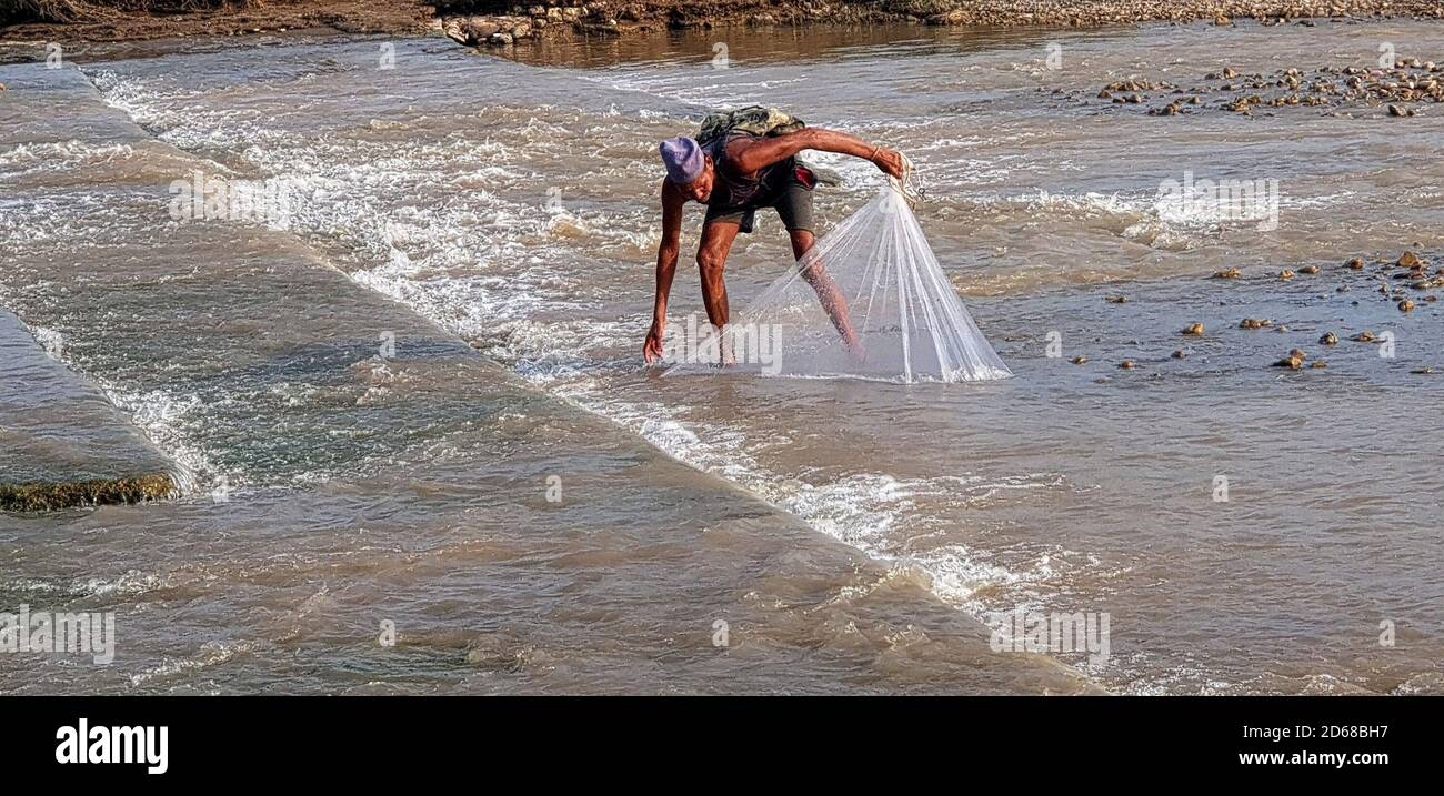 Dang, Nepal. 15th Oct, 2020. A man uses his fishing net to catch fishes ...