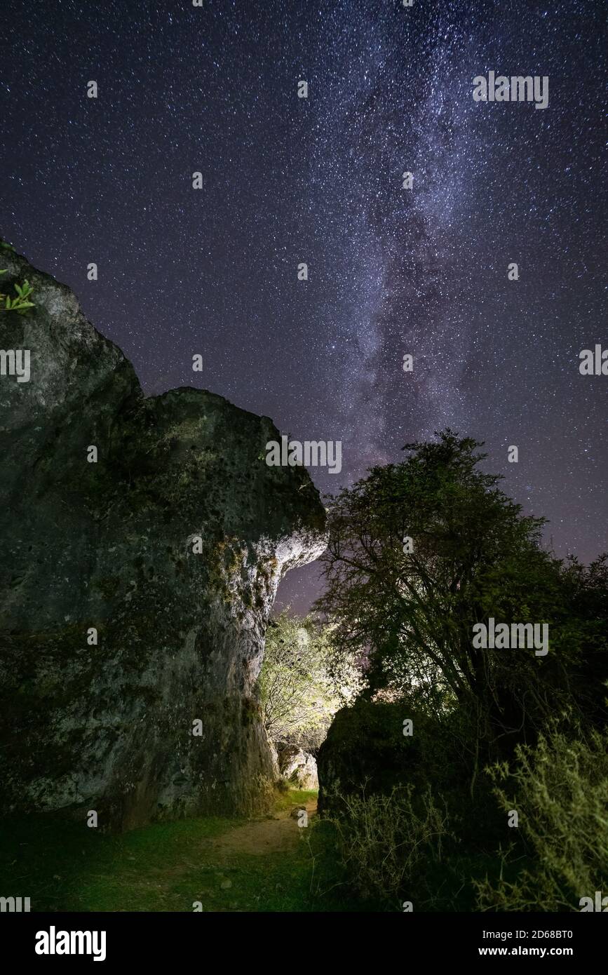 Narrow illuminated space between rocks under milky way Stock Photo - Alamy