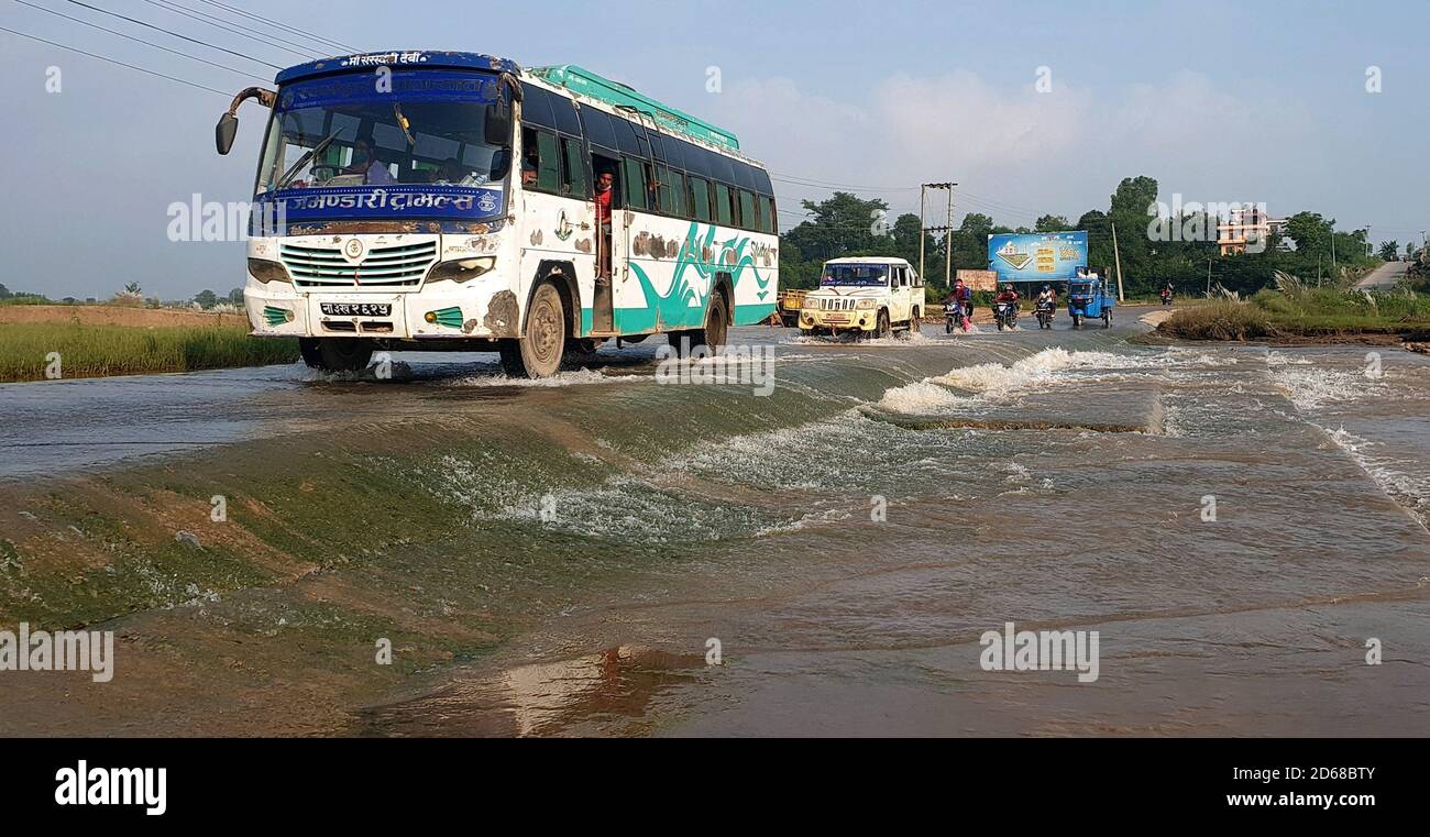 Dang, Nepal. 15th Oct, 2020. Vehicles cross a river flowing along the ...