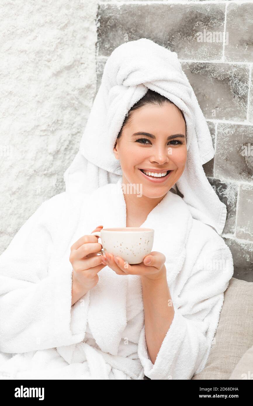Salt air treatment in the salt room. Beautiful positive woman drinking ...