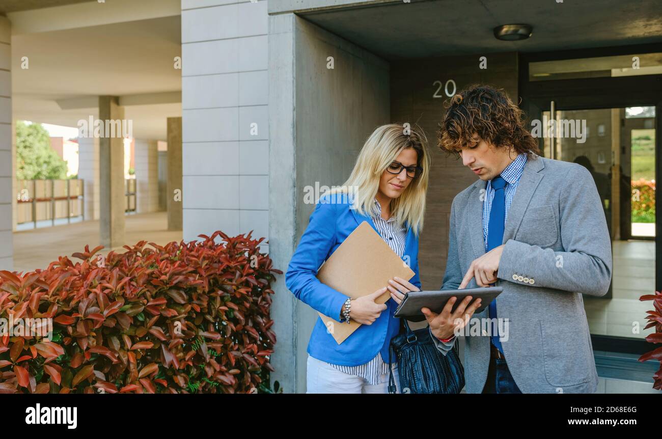 Businesspeople checking documents in the street Stock Photo - Alamy