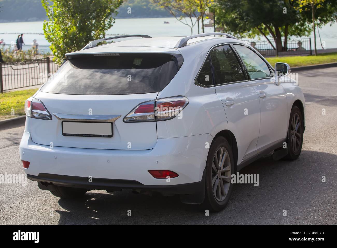 White crossover moves the road along the lake Stock Photo - Alamy