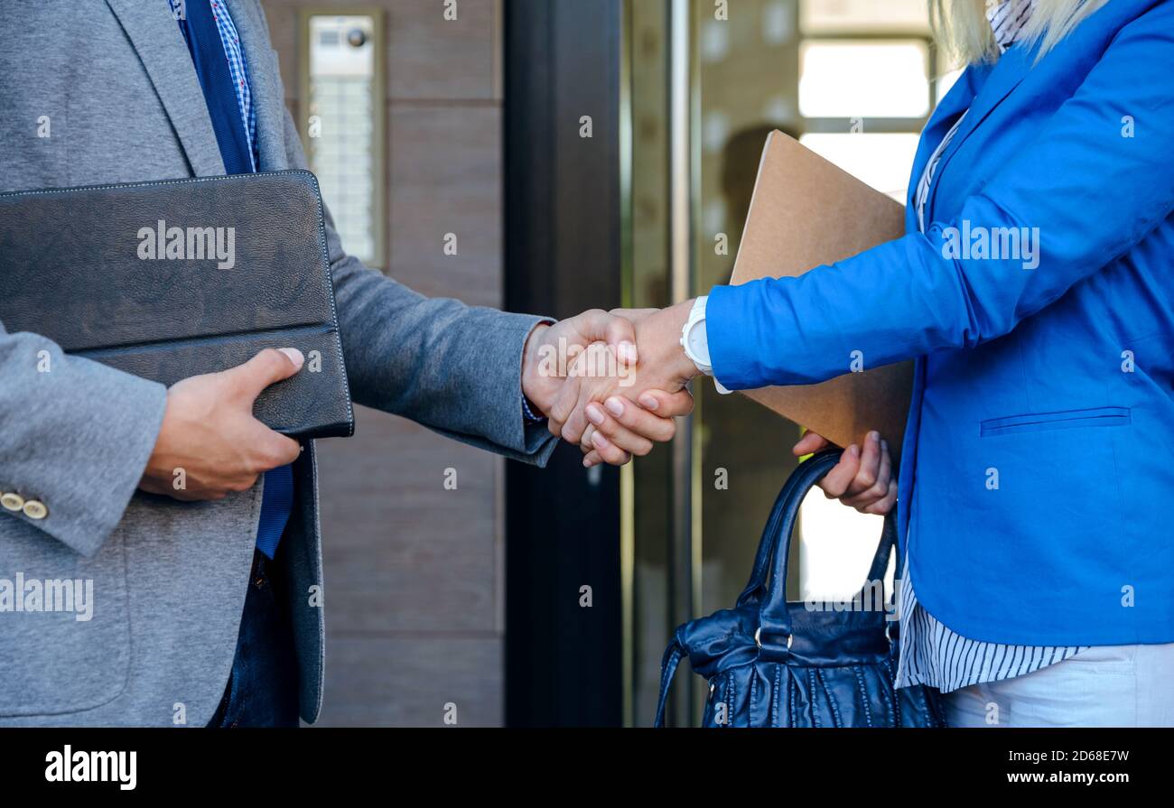 Businessman and businesswoman giving a handshake Stock Photo - Alamy