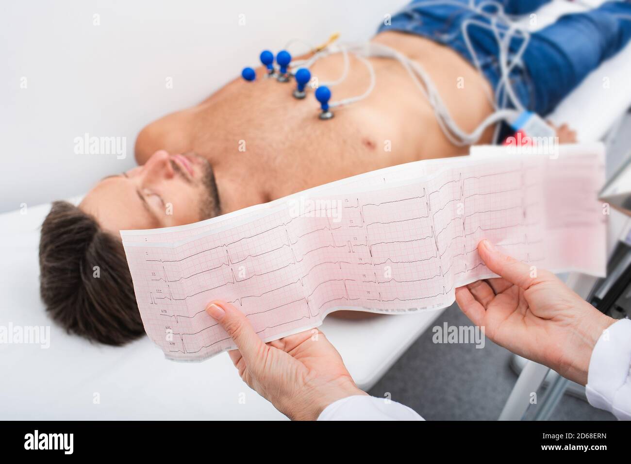 doctor holding a cardiogram test, close-up of ECG report over a male ...