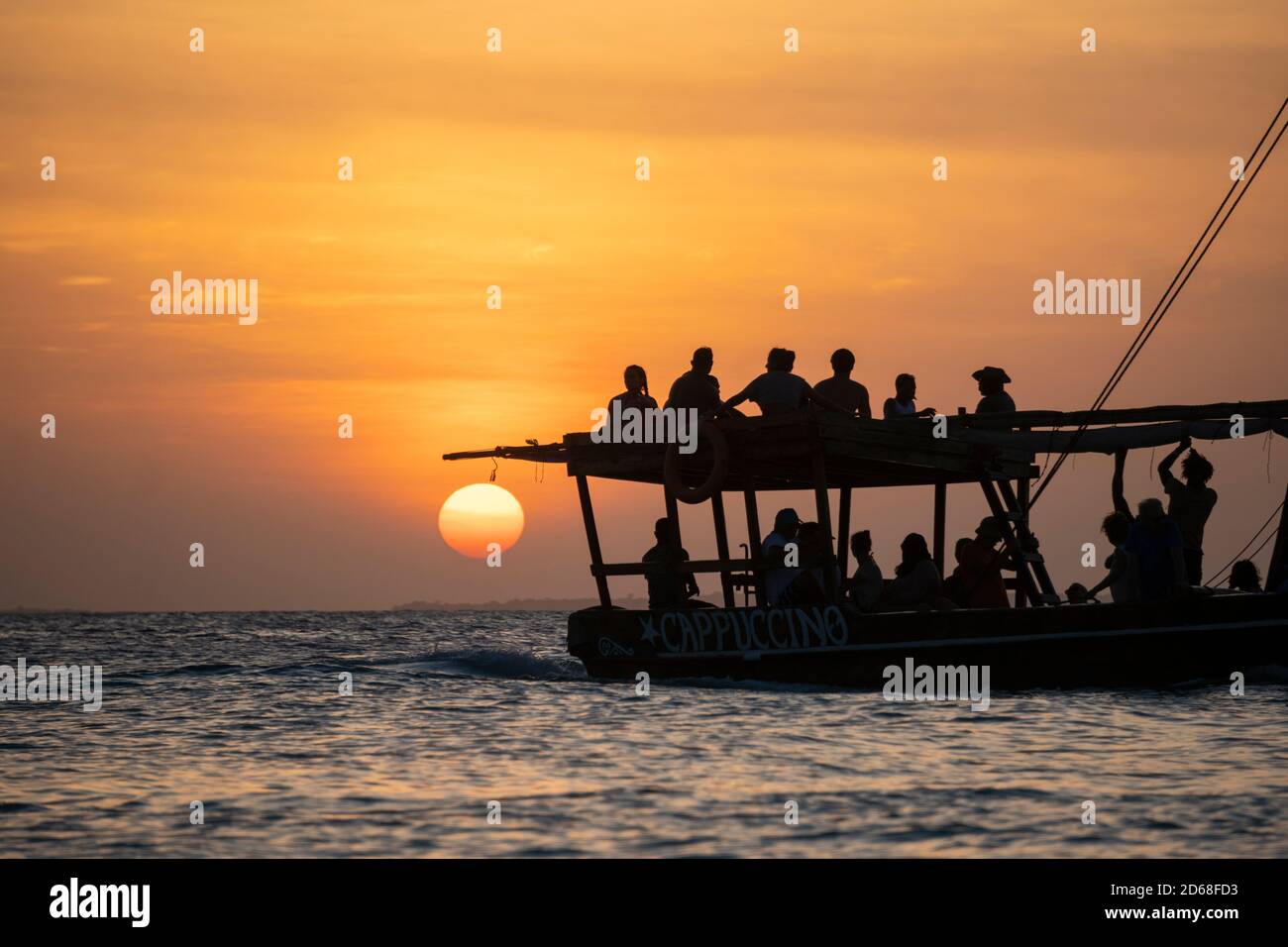 Dhow sailing during sunset in Zanzibar. Dhow is a wooden vessel with a ...
