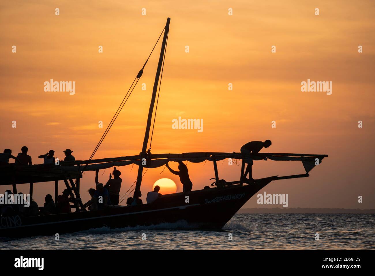 Dhow sailing during sunset in Zanzibar. Dhow is a wooden vessel with a ...