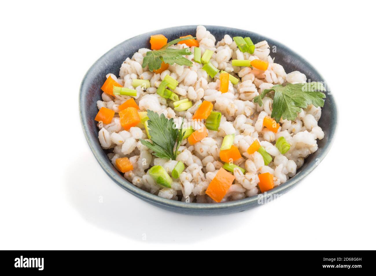 Pearl barley porridge with vegetables in blue ceramic bowl isolated on ...