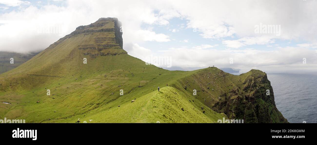 Kallur Lighthouse on Kalsoy Island with green lush cliff landscapes and ...