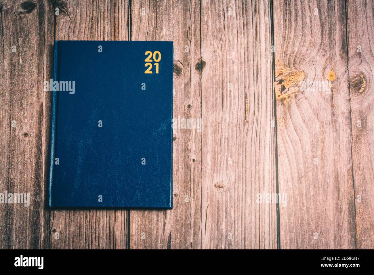 a blue 2021 diary placed on a rustic wooden desk Stock Photo - Alamy