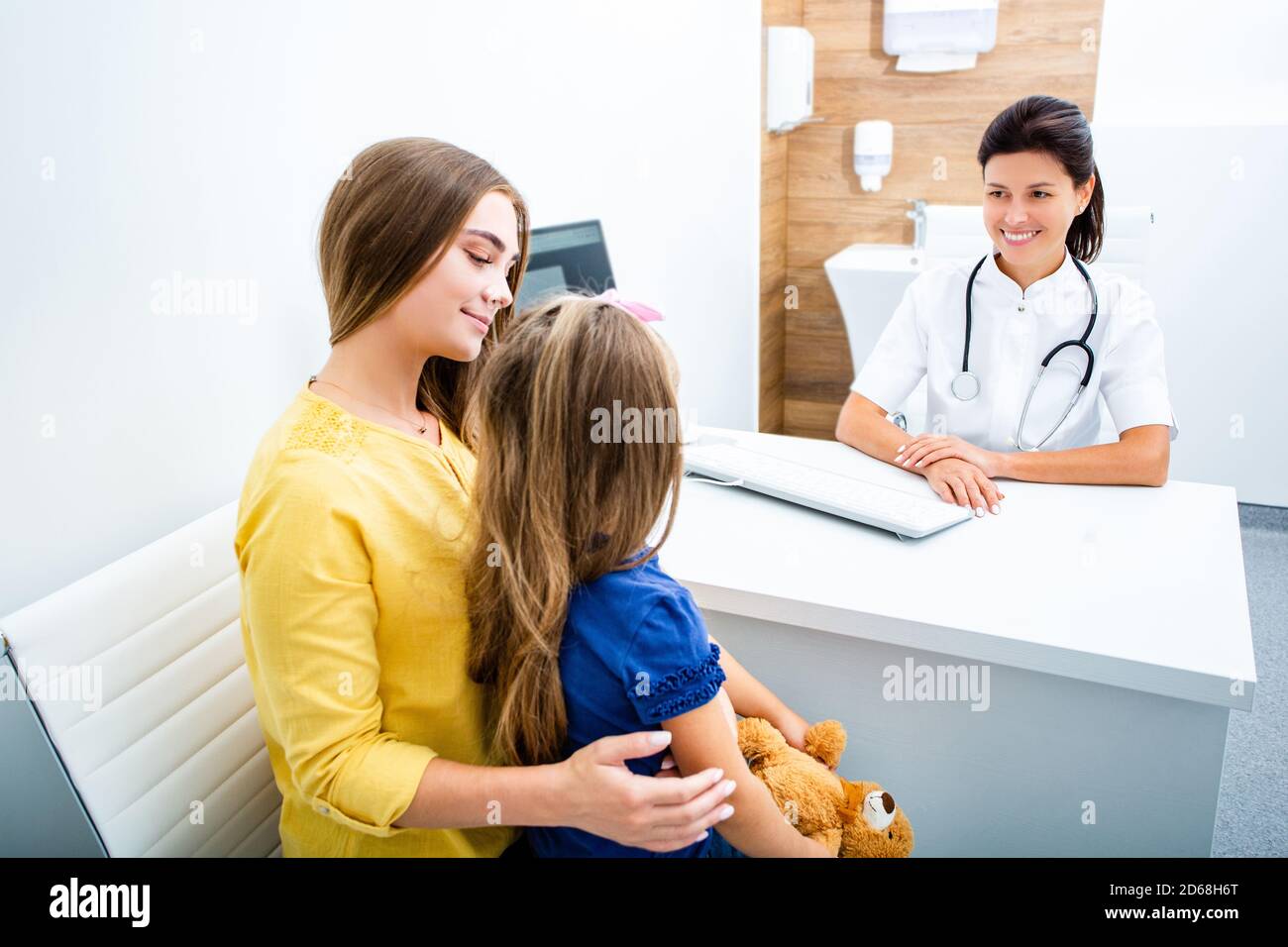 Friendly pediatrician meeting with mother and child in the hospital ...
