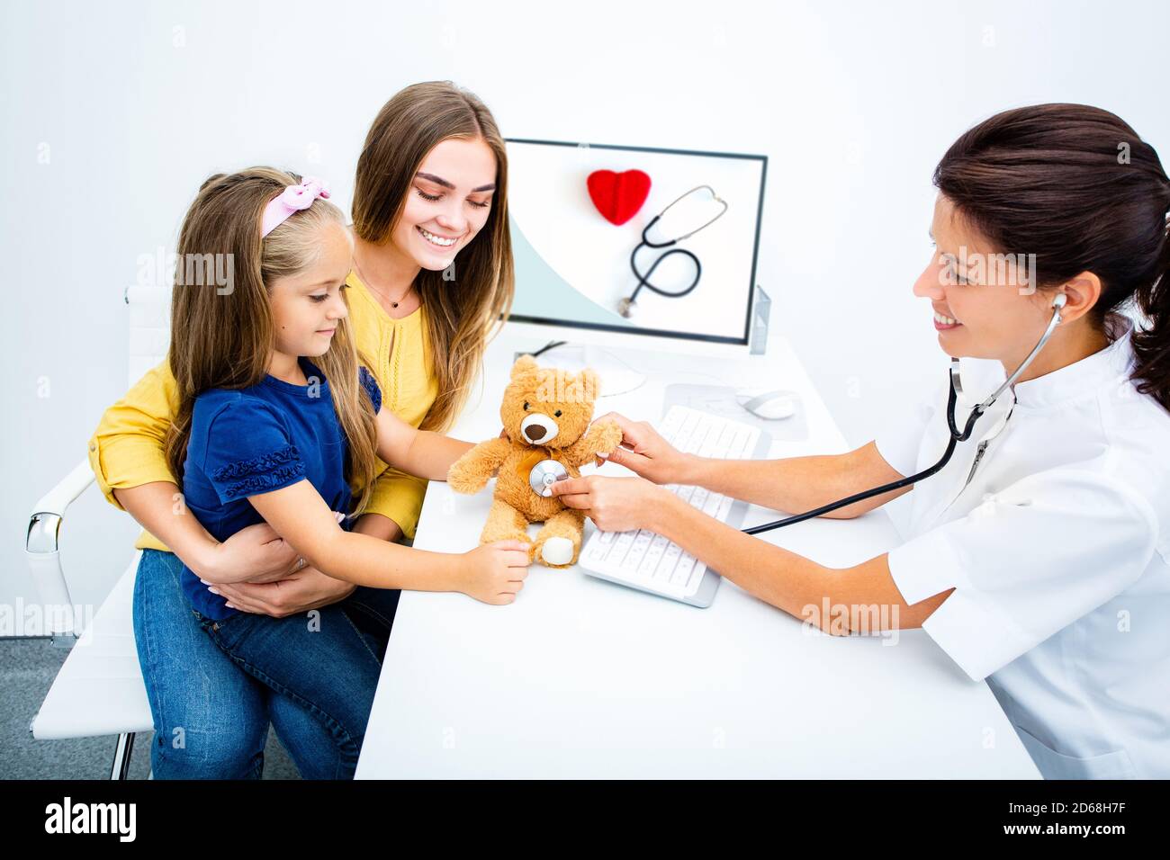 Friendly pediatrician having fun with her child patient at the hospital ...