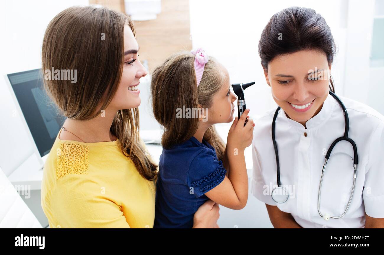 little girl who sitting in her mother's arms and looking through the ...