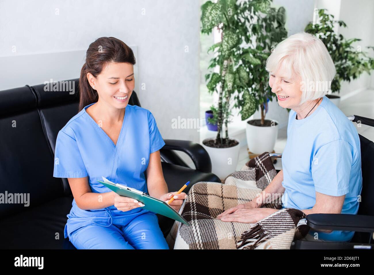 Nurse shows test results to an elderly patient who is sitting in a ...
