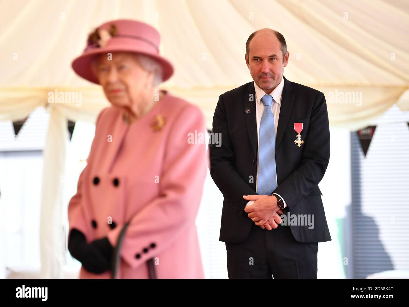 Queen Elizabeth II, with Professor Tim Atkins who was honoured for his ...
