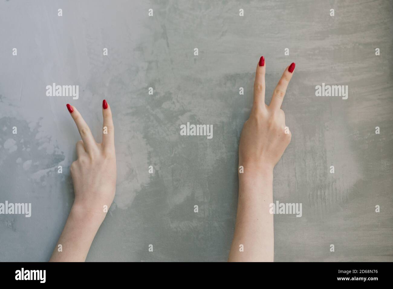 Isolated woman's hands with red nails in front of a grey wall Stock ...