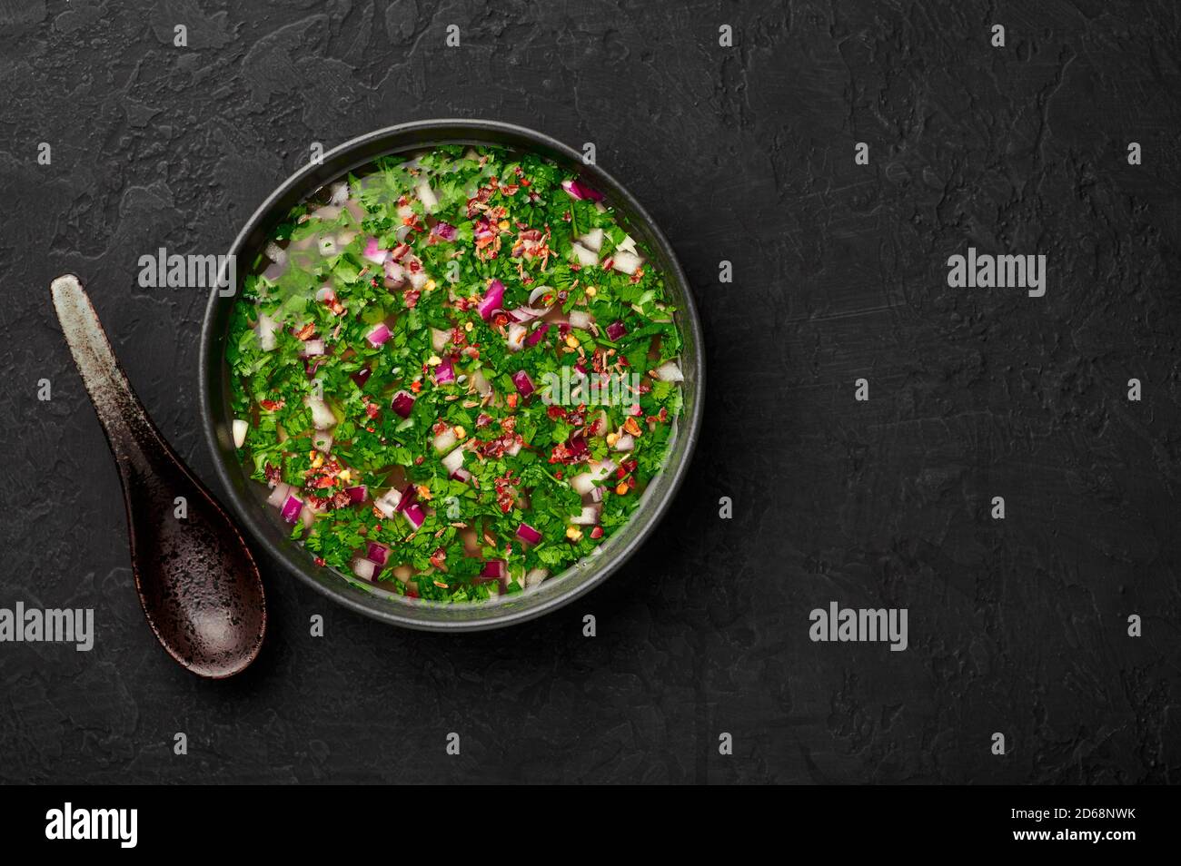 Pachi Pulusu in black bowl on dark slate table top. Raw Tamarind Rasam ...