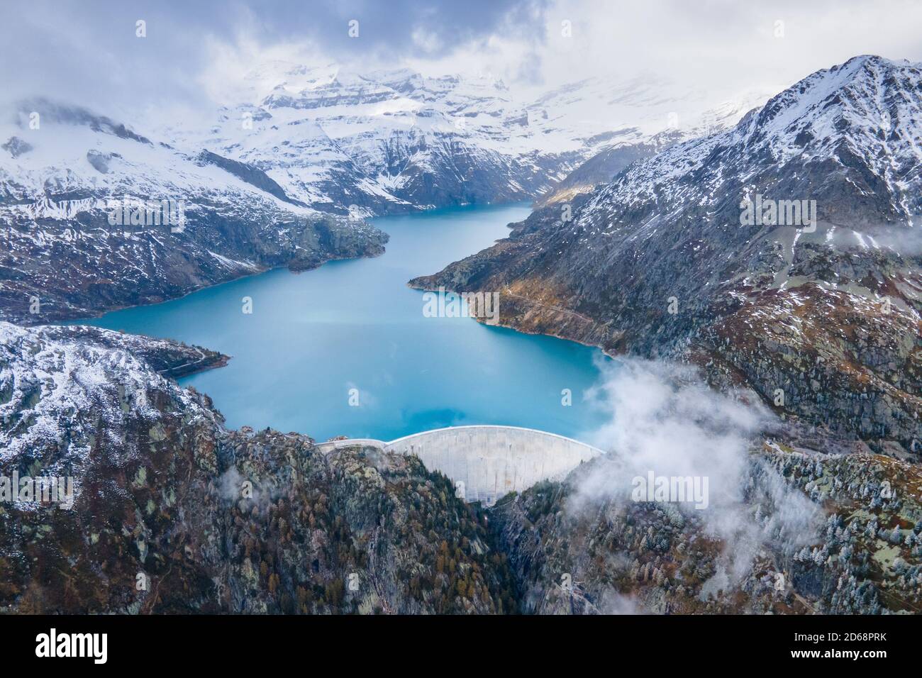 Hydropower generated from arch dam and reservoir lake in snow covered ...