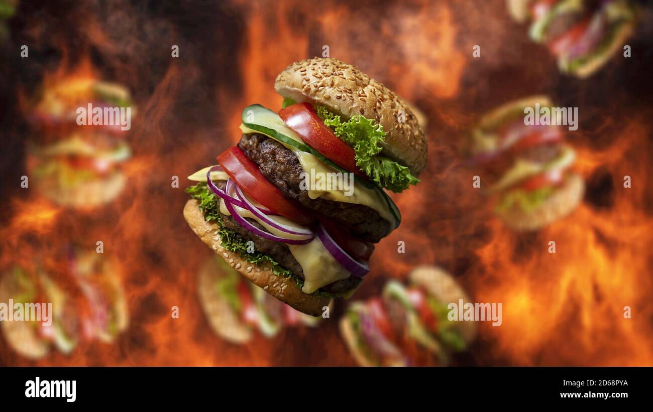 Hamburgers falling with smoke and burning fire in background. Fast food ...