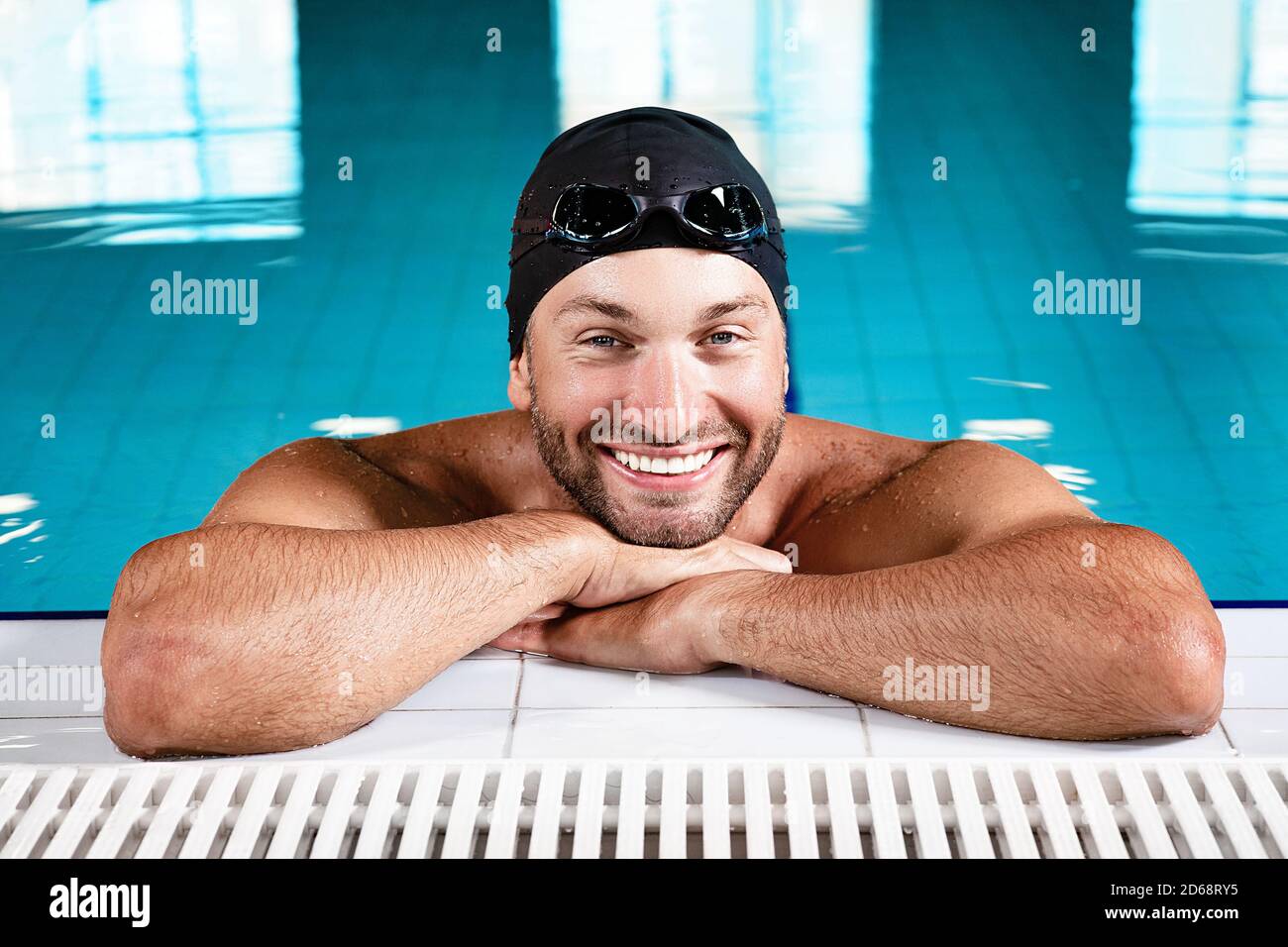 Portrait of smiling man, a swimmer on the rooftop pool. Swimmer in the ...
