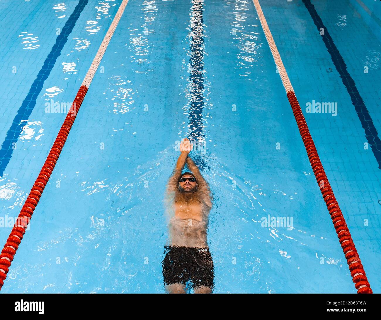 Swimmer floating in the swimming pool, top view. Man swimming on the ...