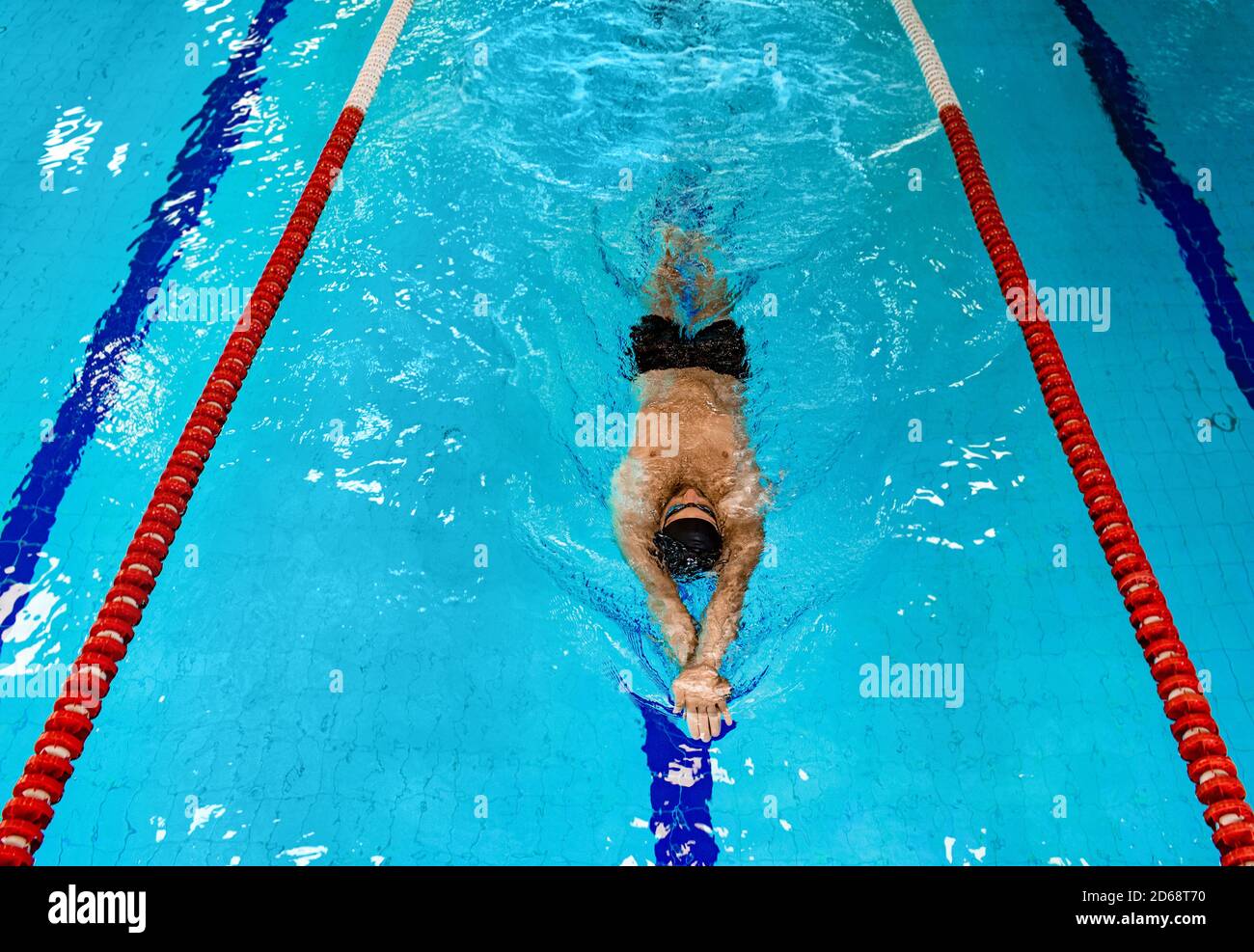 Swimmer floating in the swimming pool, top view. Relaxing bode on blue ...