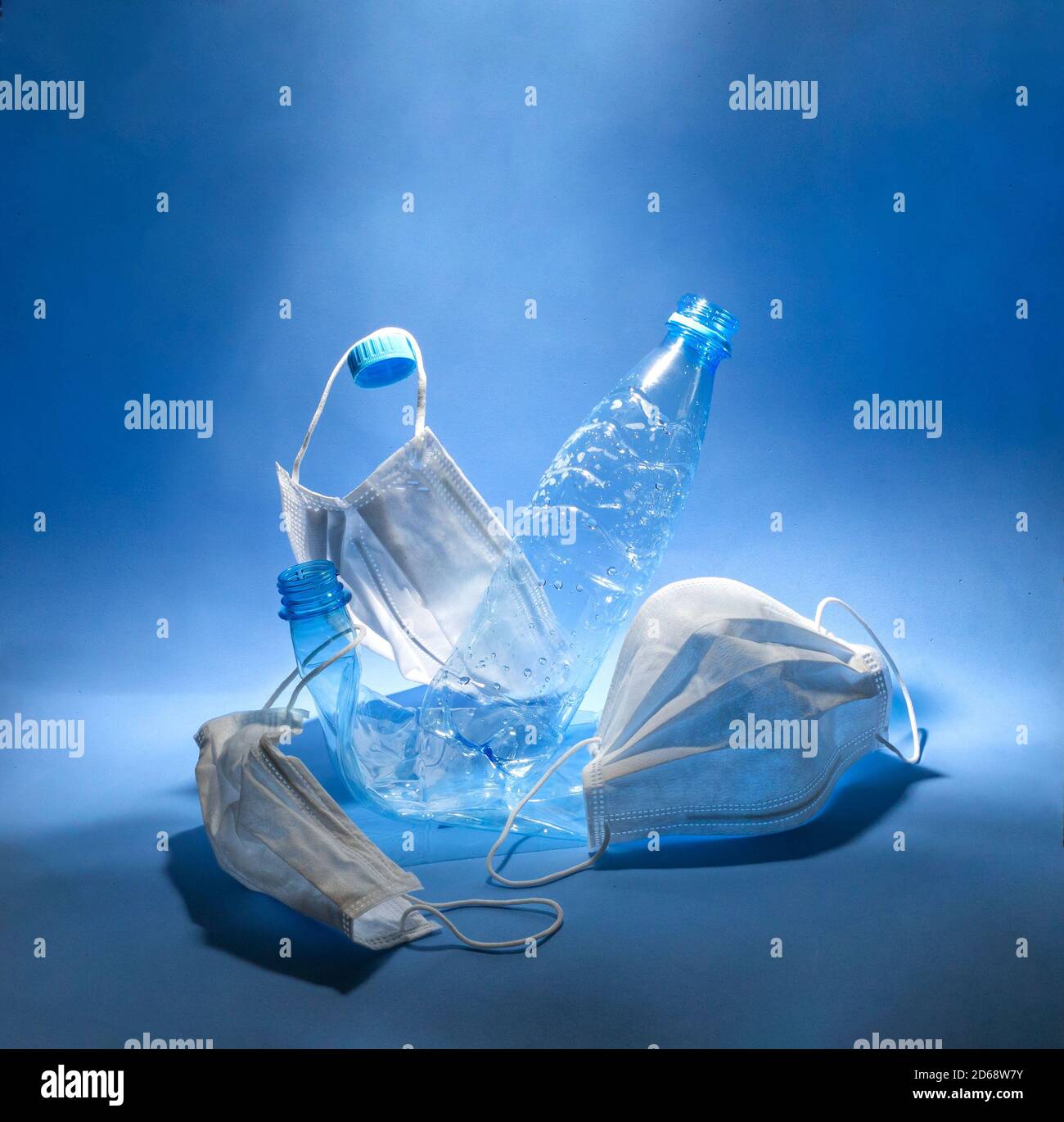 Used blue plastic bottles and white masks on a blue background ...
