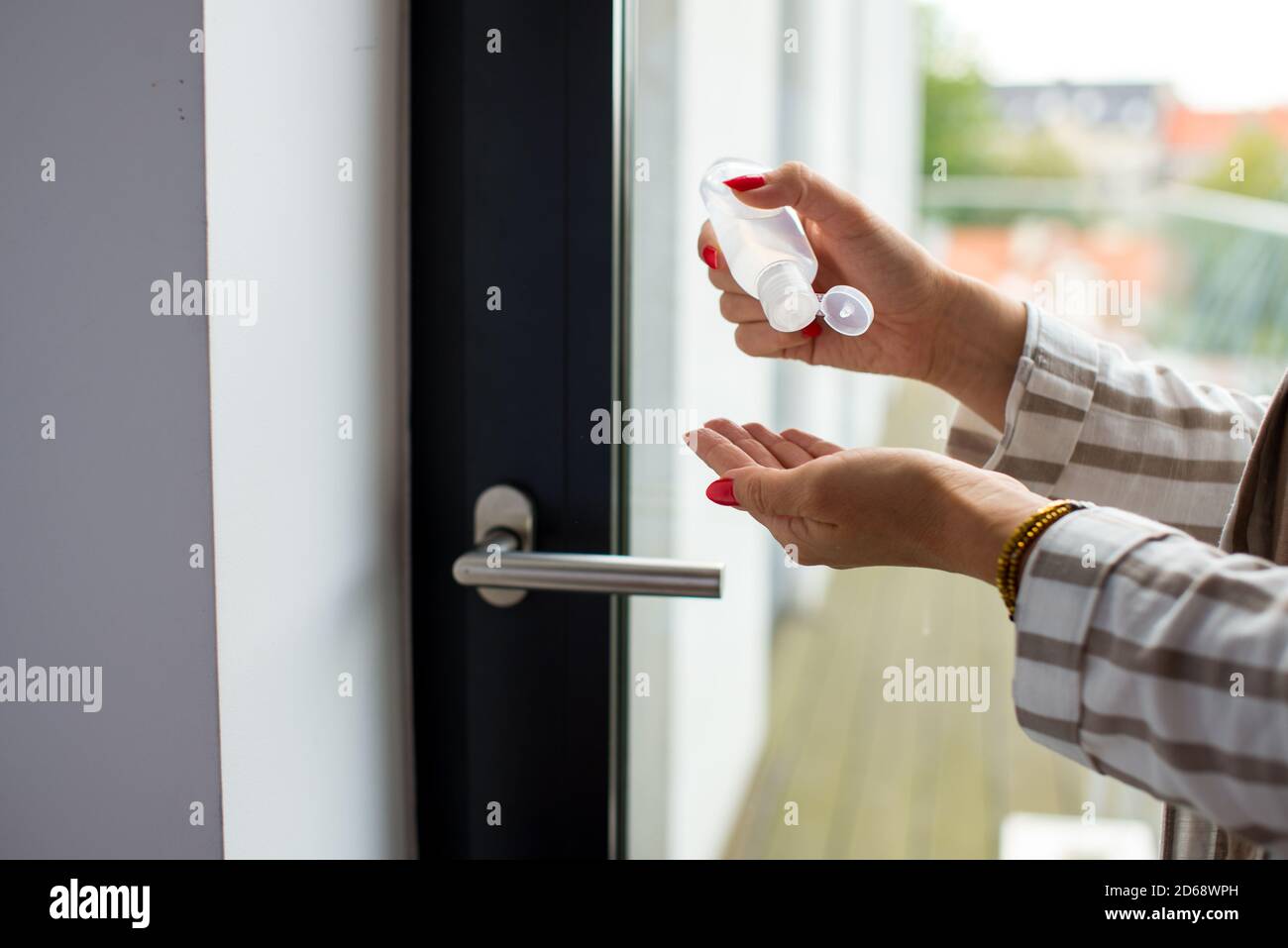 Woman's hand with clean gel to wash hands to kill germs before going in ...