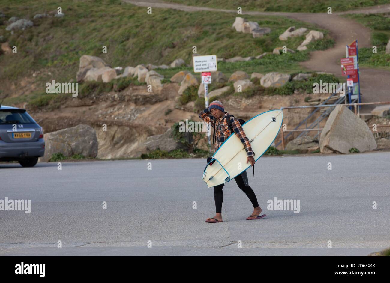 Glorious sunshine over Fistral Beach in Newquay,Cornwall. A man carries ...