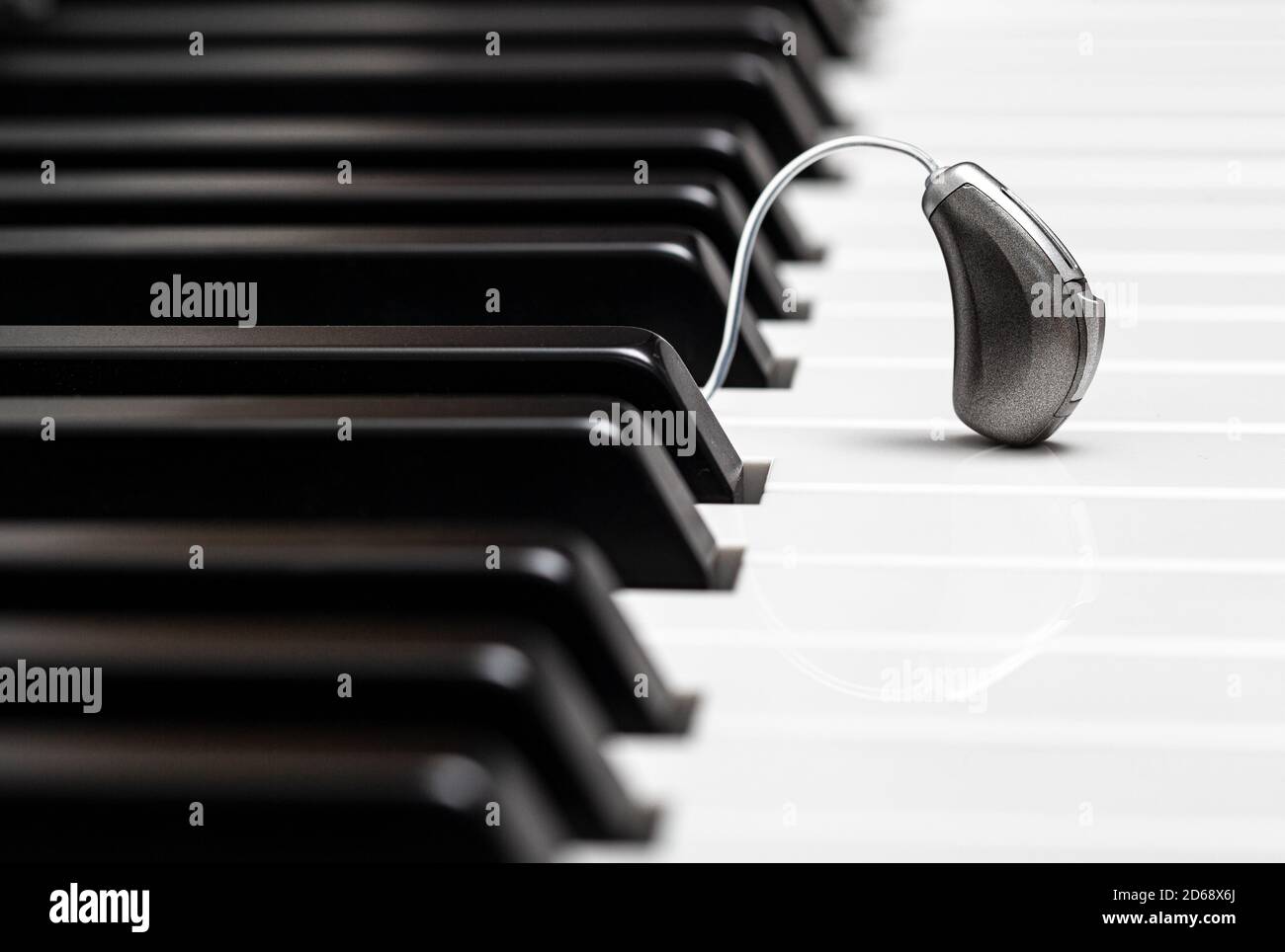 Close-up hearing aid on piano keys. Treatment of deafness. Hearing ...