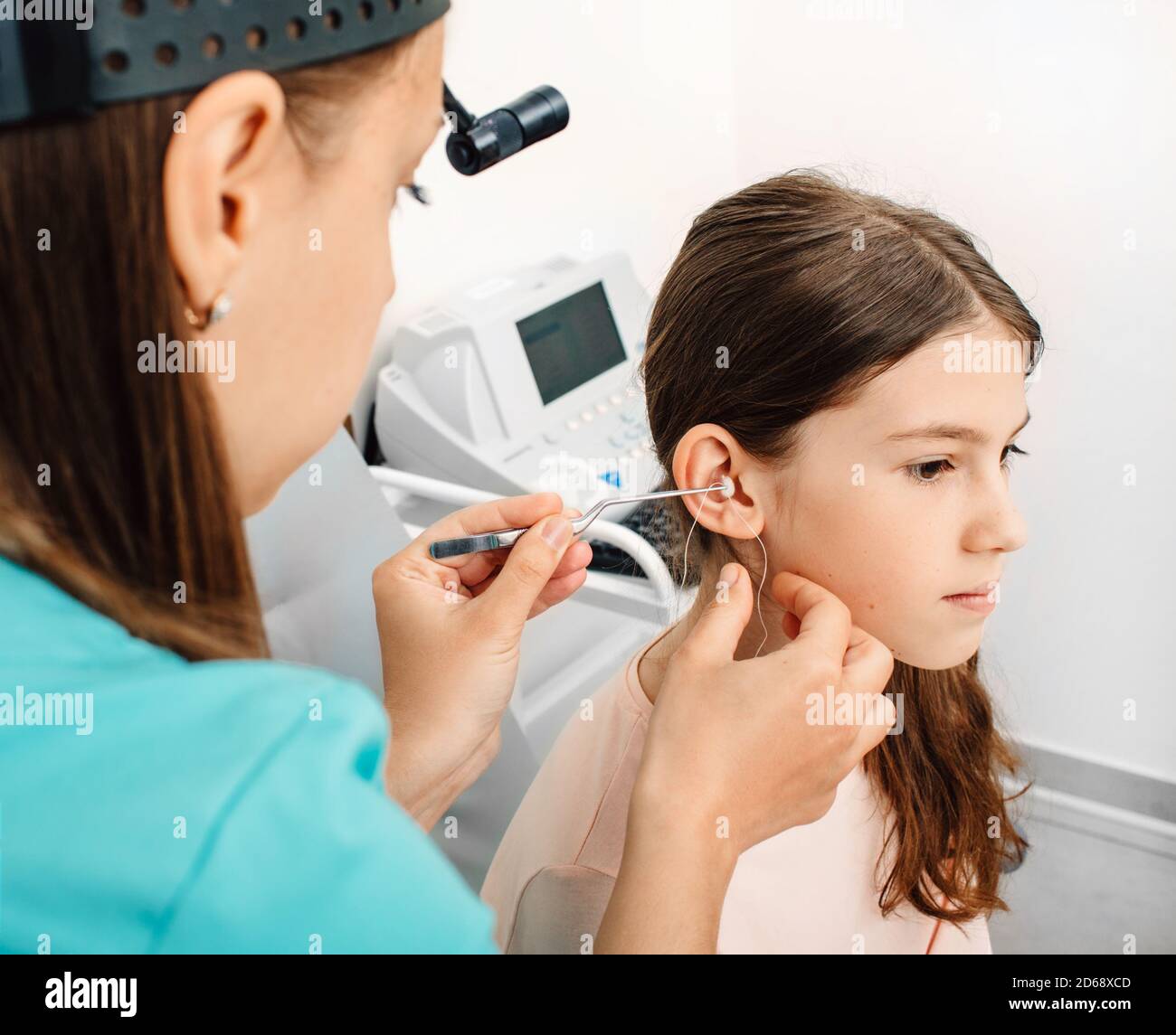 Hearing test. Positive girl in headphones during a hearing test ...
