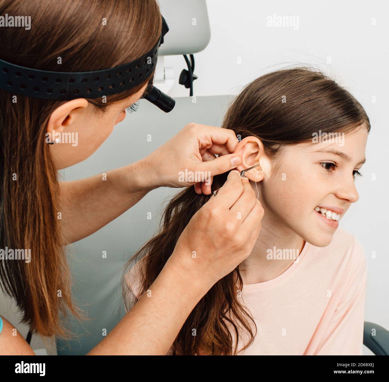 Hearing test. Positive girl in headphones during a hearing test ...