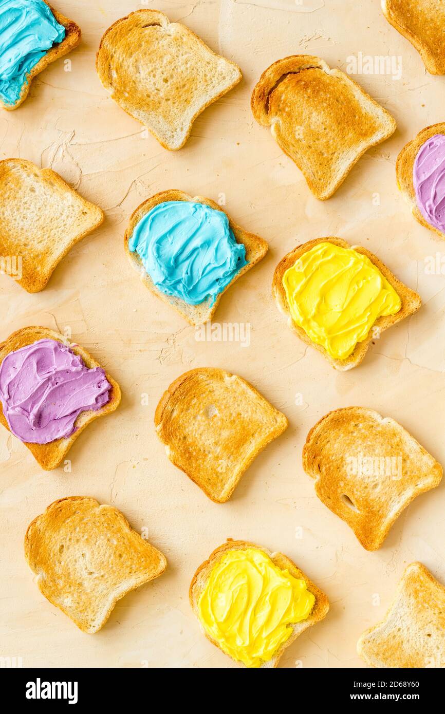 Pattern of toast bread with colored cheese spread. Layout top view ...
