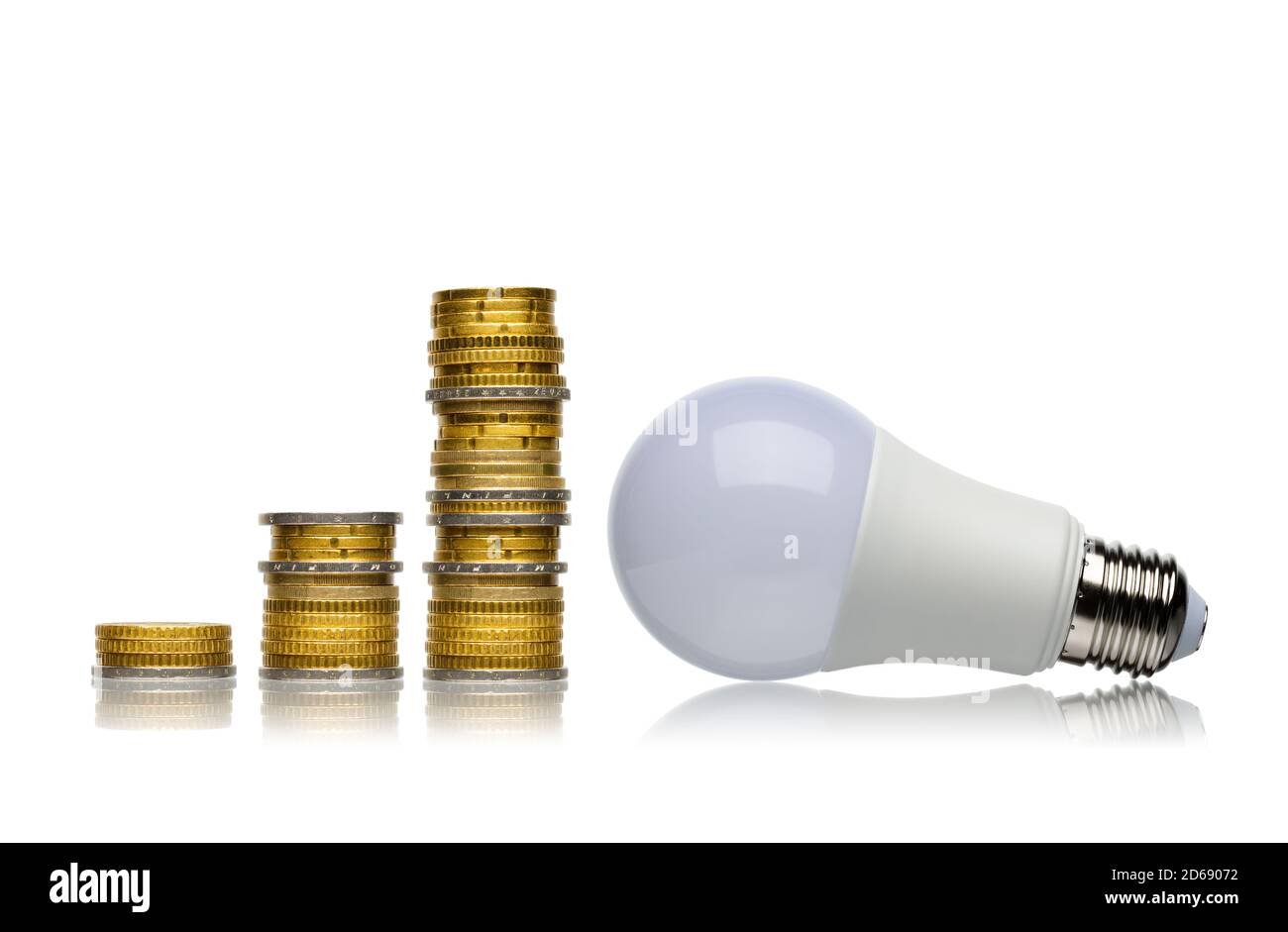 Energy saving lamp and column stack of coins isolated on white ...