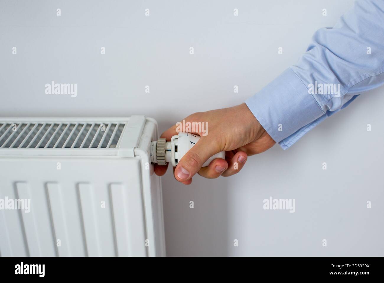 Male Hand Adjusting The Knob Of Heating Radiator. A hand that regulates ...