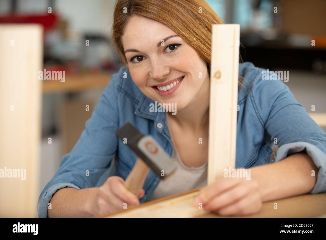 happy woman carpenter using hammer Stock Photo - Alamy
