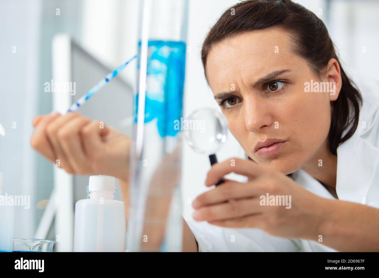 young attractive female scientist dropping a liquid Stock Photo - Alamy