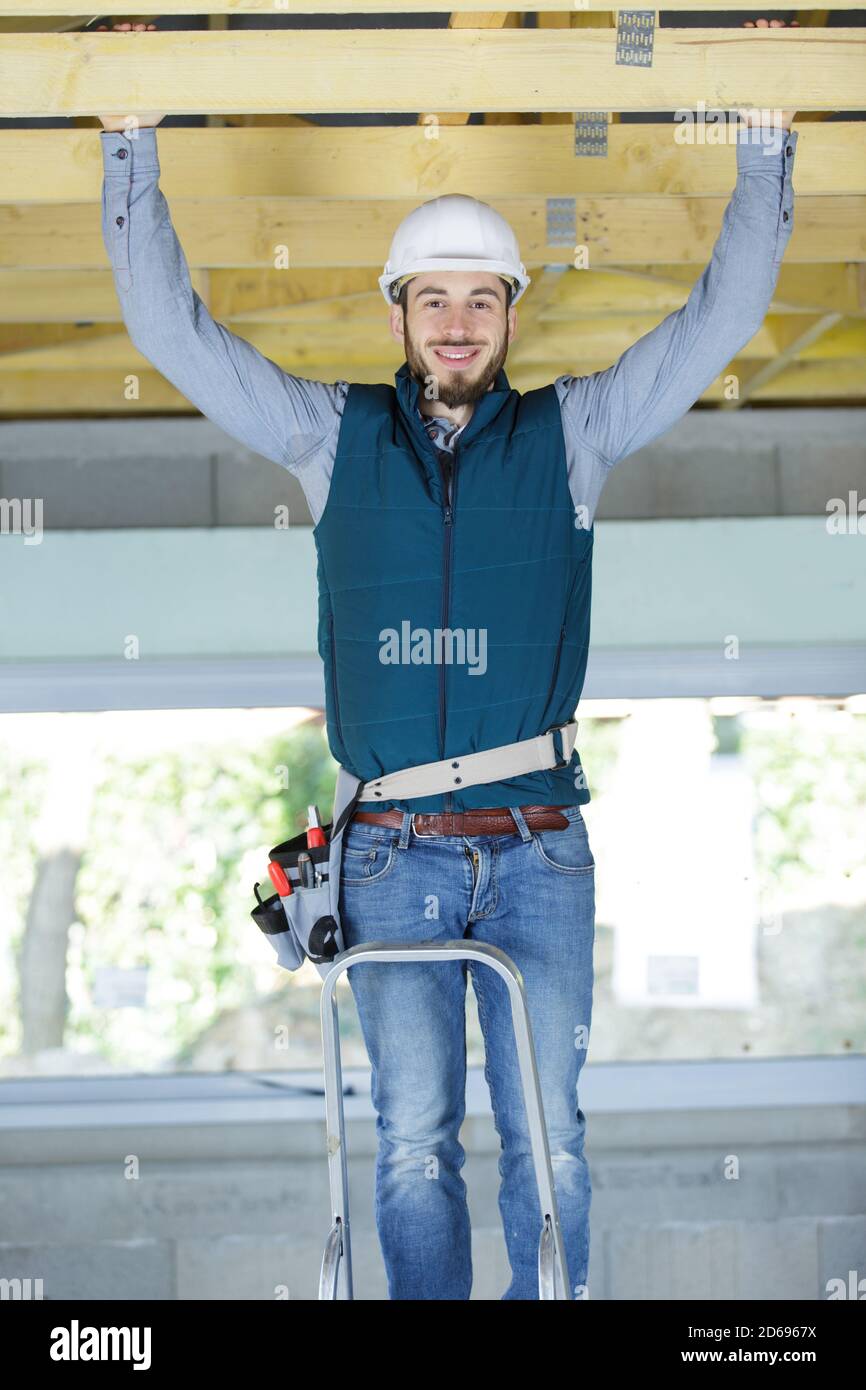 man on ladder working on a wodden roof Stock Photo - Alamy
