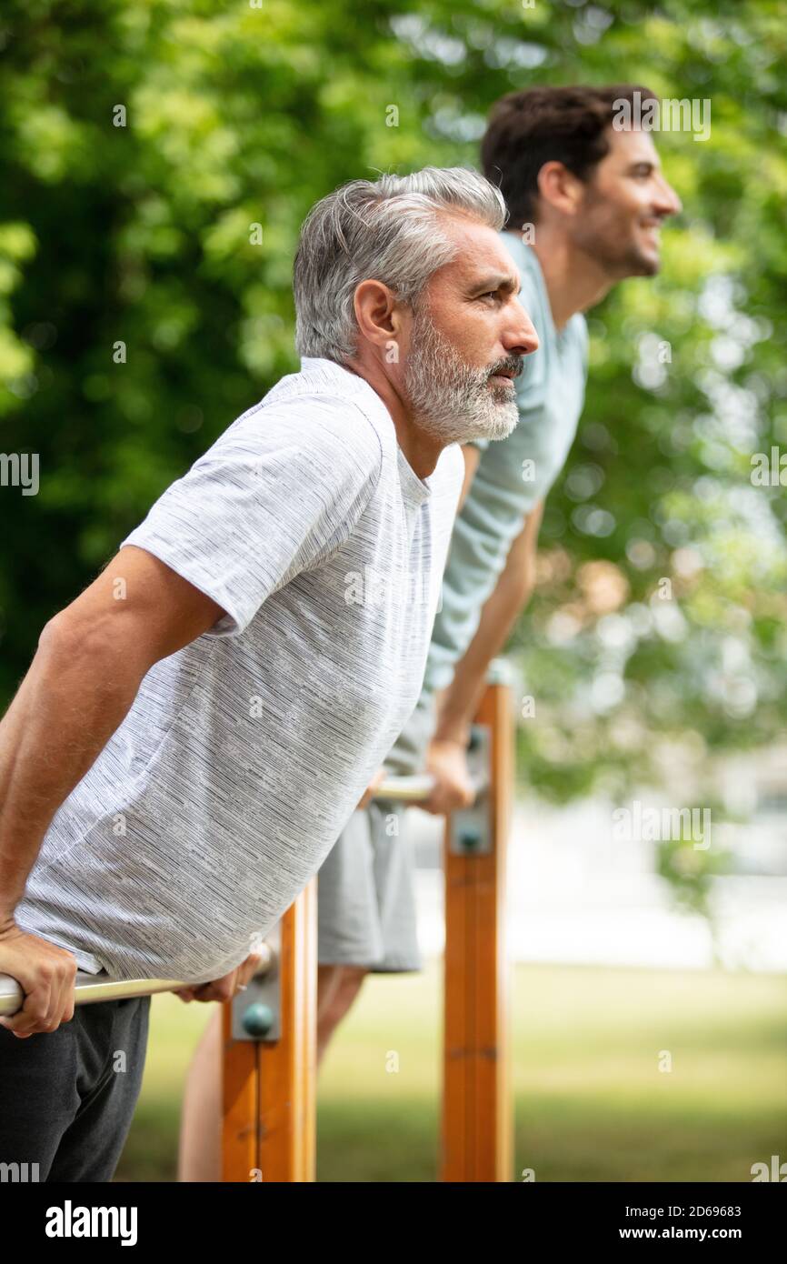 two motivated men doing dips exercise Stock Photo - Alamy