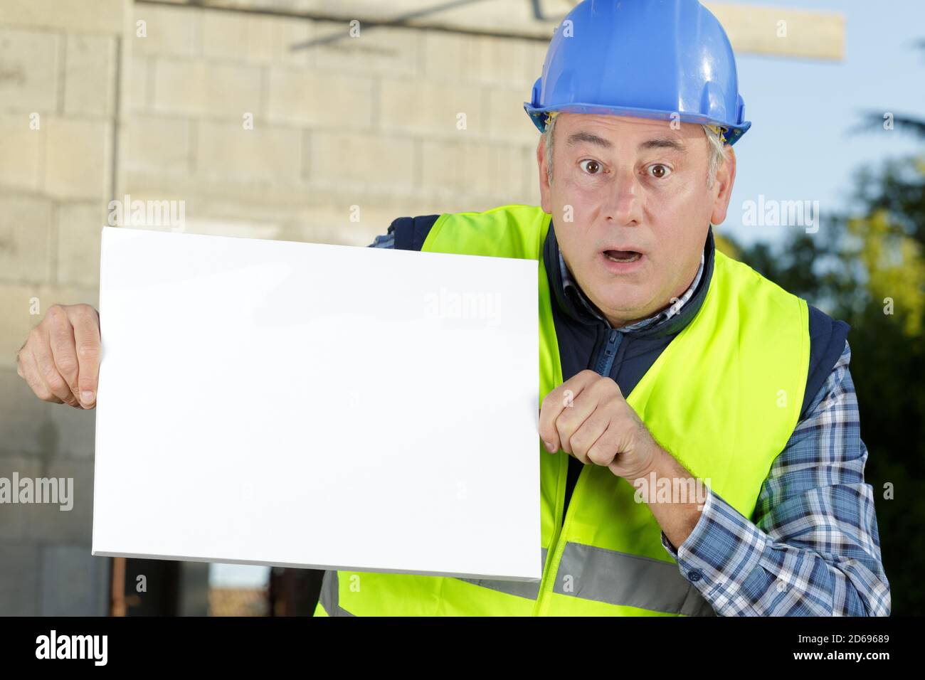 shocked male construction worker holding blank board Stock Photo - Alamy