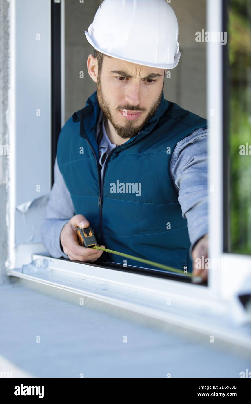 service man measuring window for installation indoors Stock Photo - Alamy