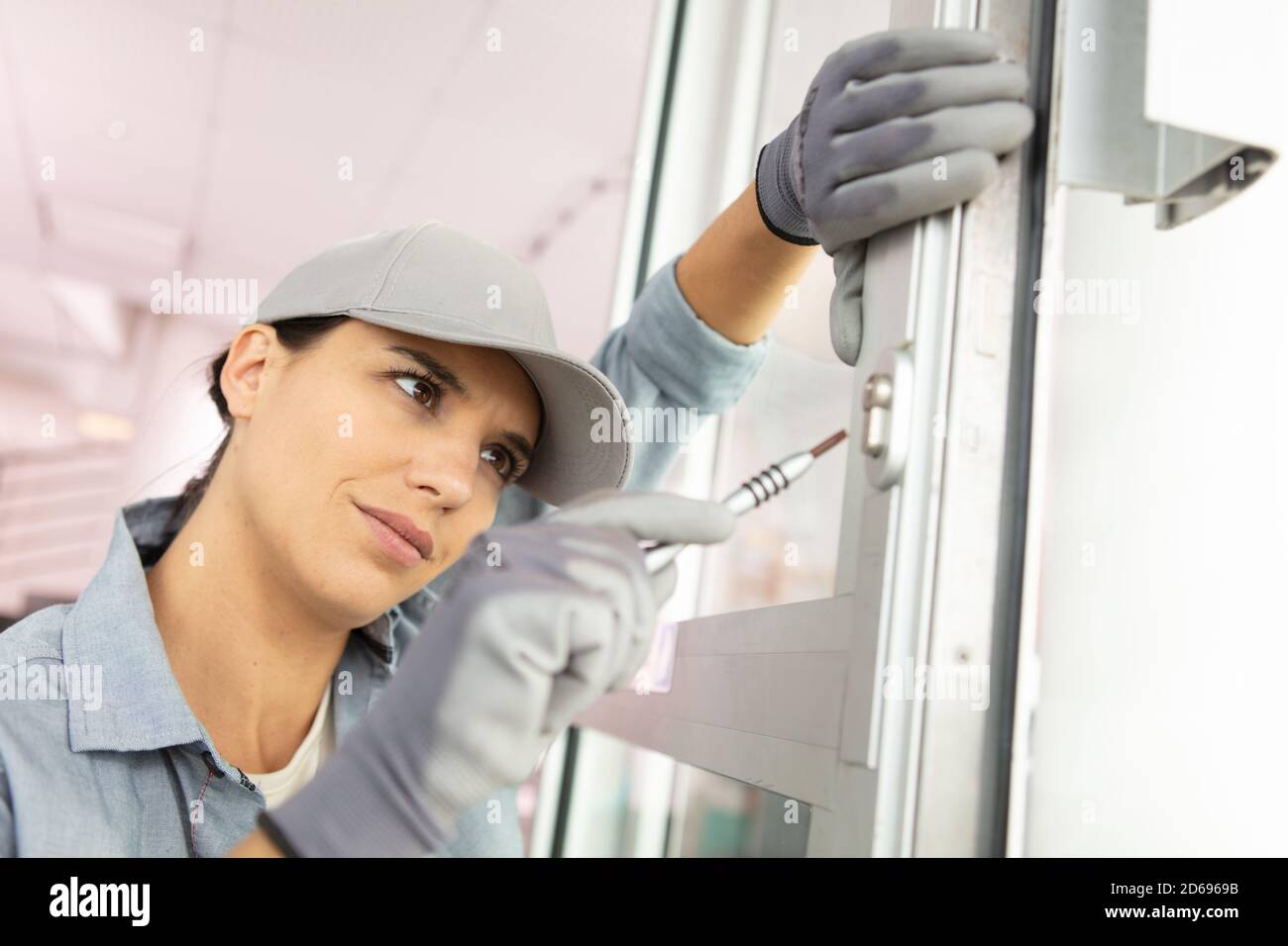 blonde woman installing window at clients home Stock Photo - Alamy