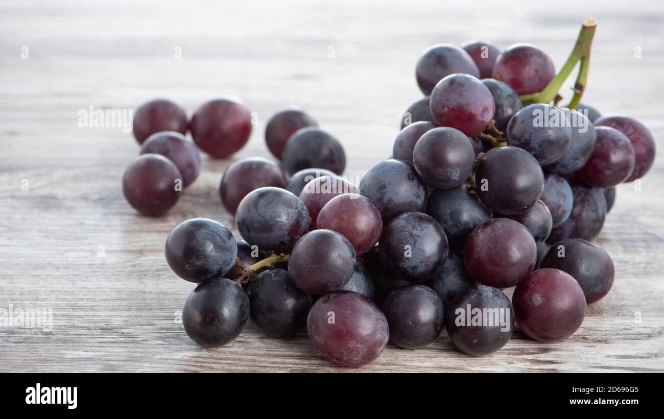 Delicious bunch of grapes fruit on a plate over wooden table background ...