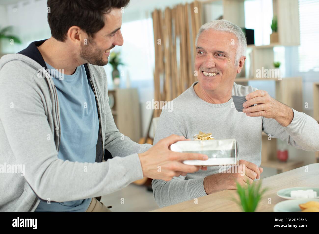son and senior father eating light lunch Stock Photo - Alamy