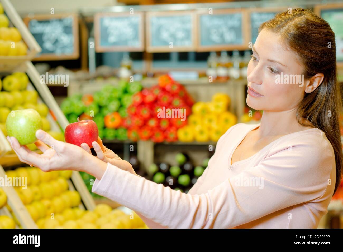 a woman is comparing apples Stock Photo - Alamy