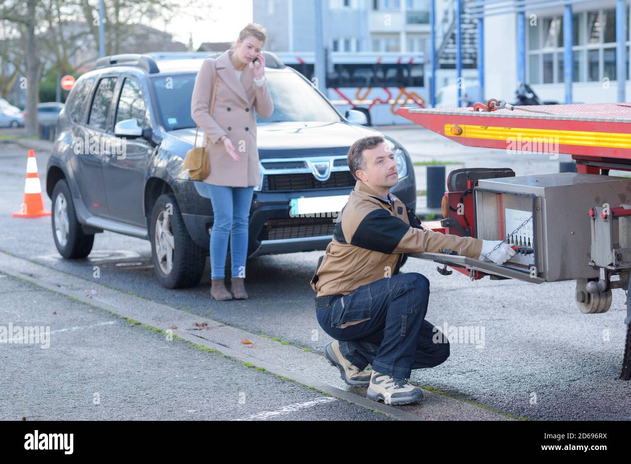male worker assisting female customer with car problem Stock Photo - Alamy